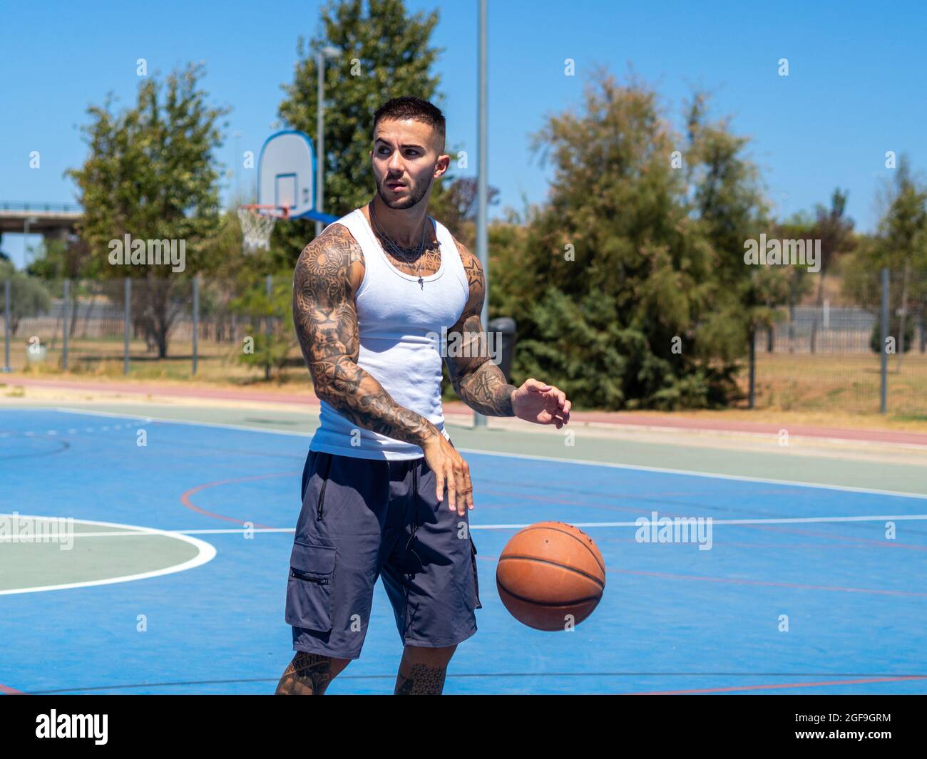 Athletic handsome Spanish basketball player training on a basketball ...