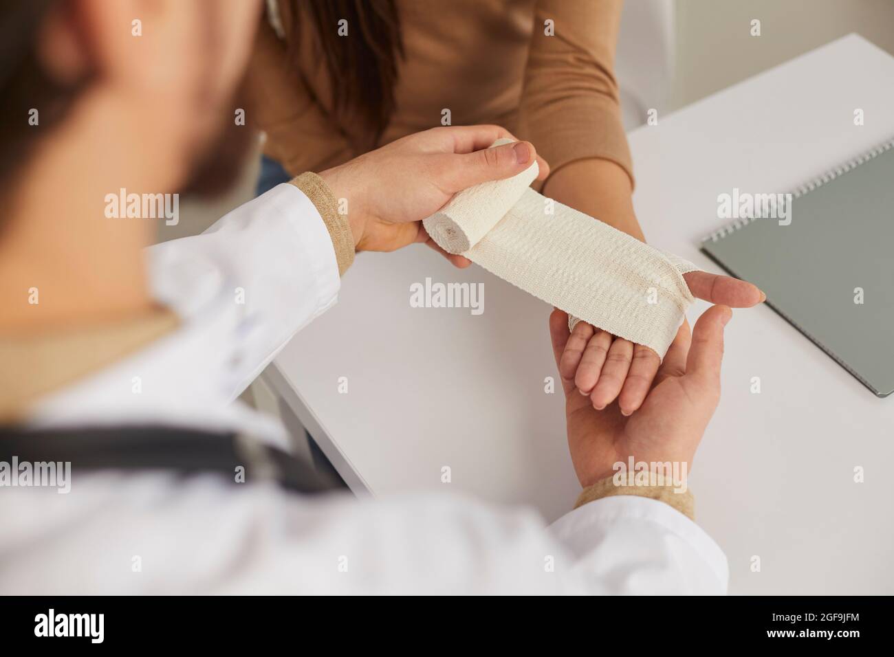 Nurse at medical office providing first aid applying bandage on patient ...