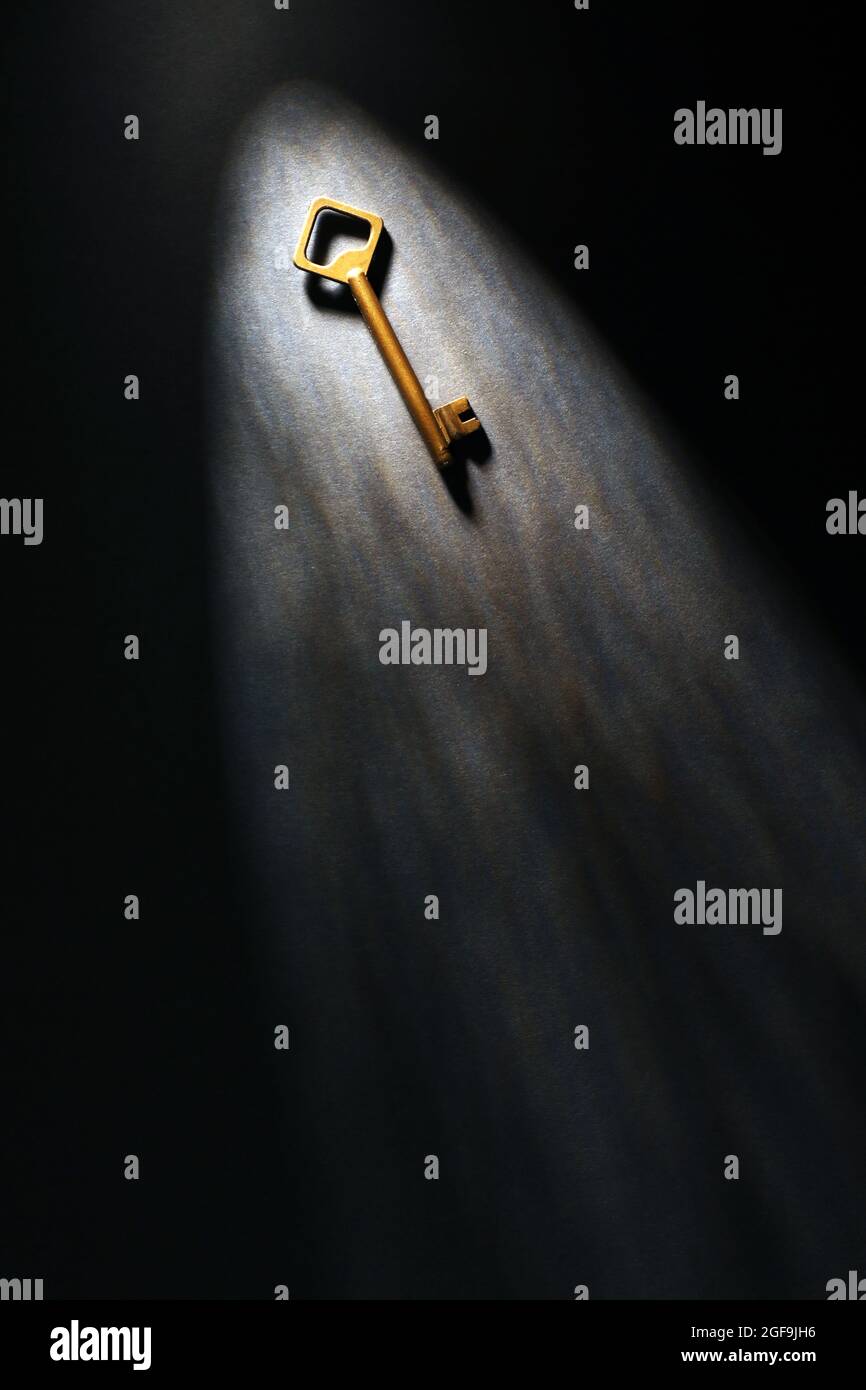 Old key on dark surface with beam of light Stock Photo - Alamy