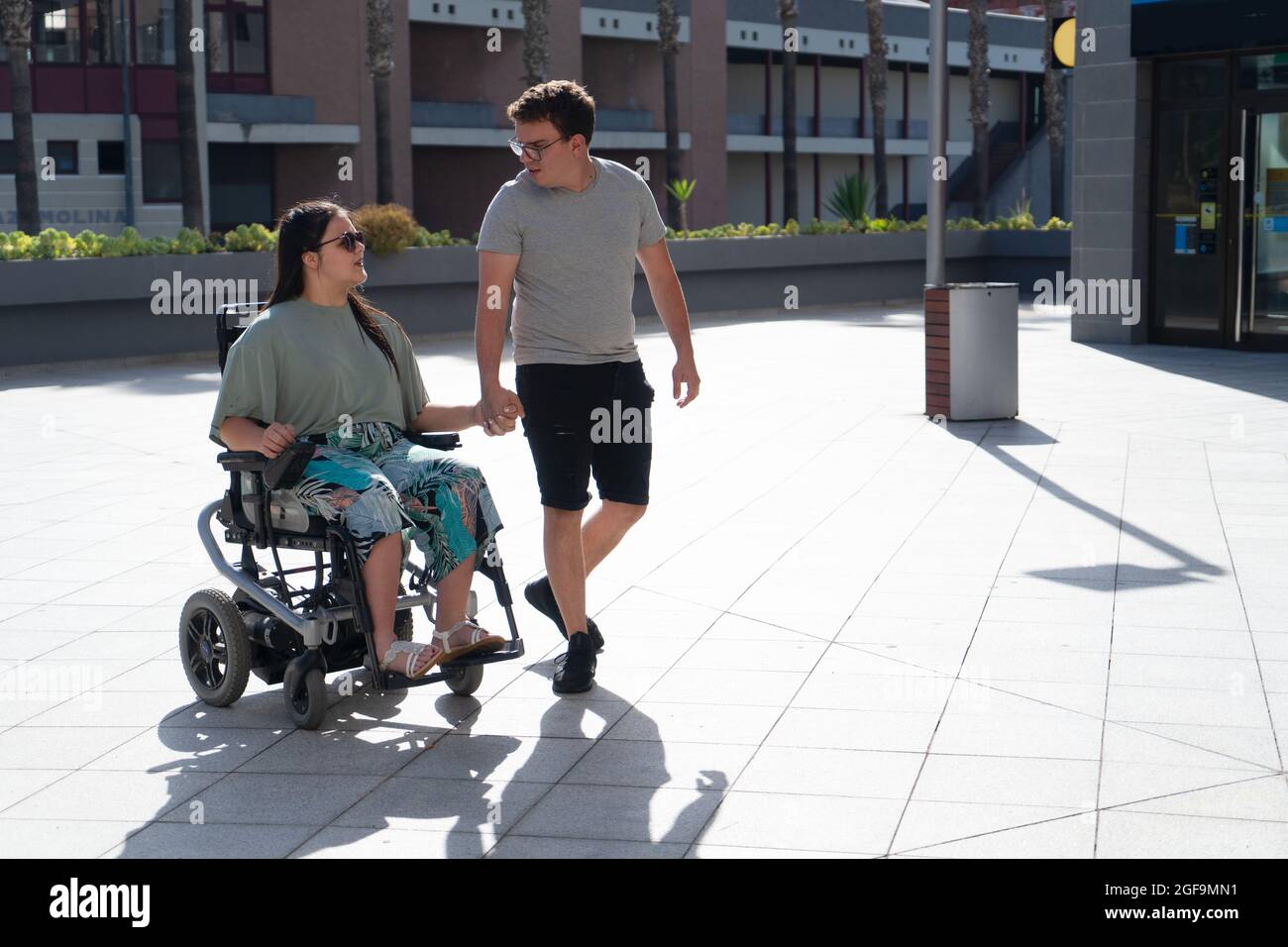 Young disabled woman in wheelchair dating with her boyfriend outdoors ...