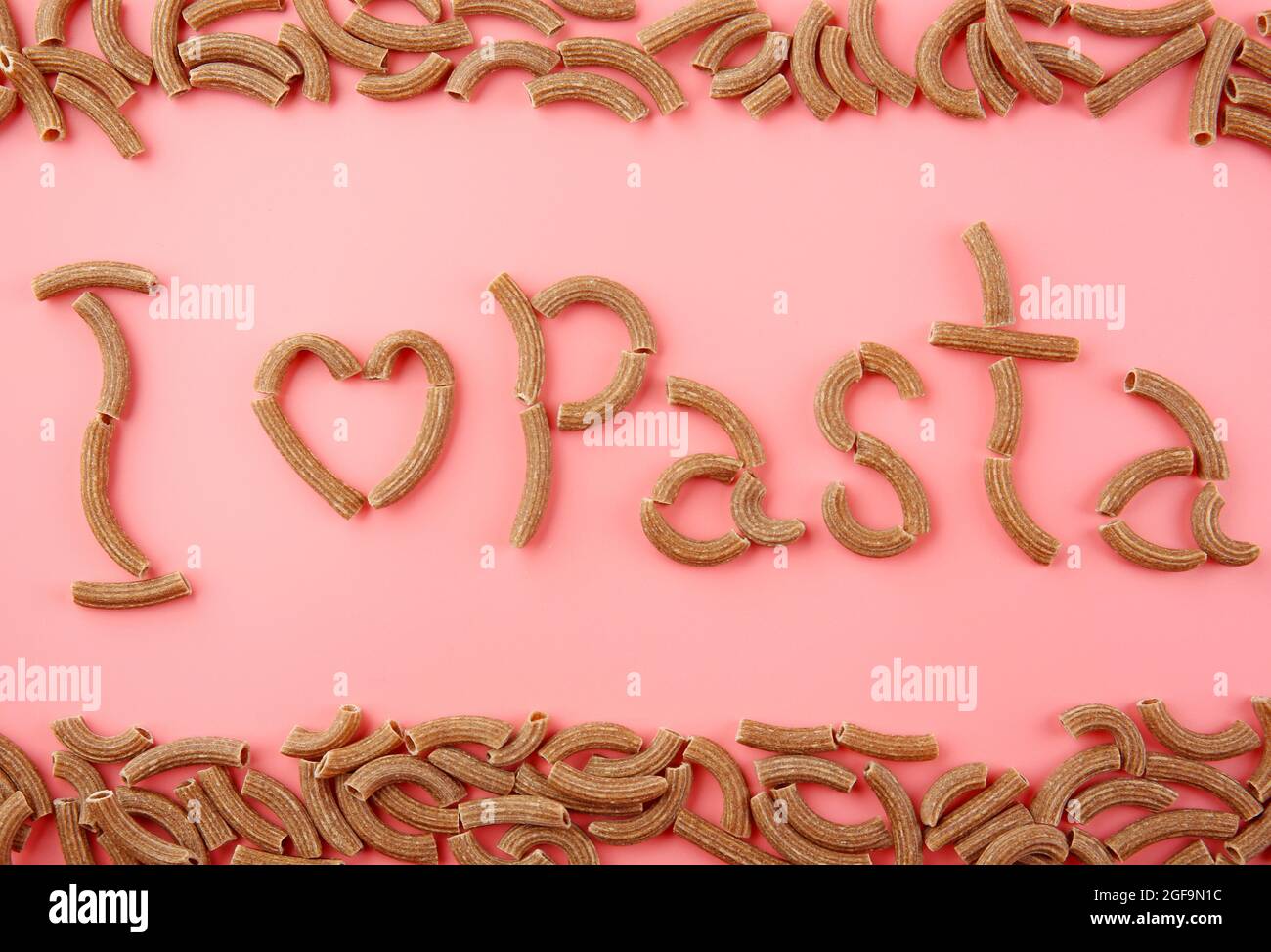 I love pasta inscription made with brown macaroni on pink background ...