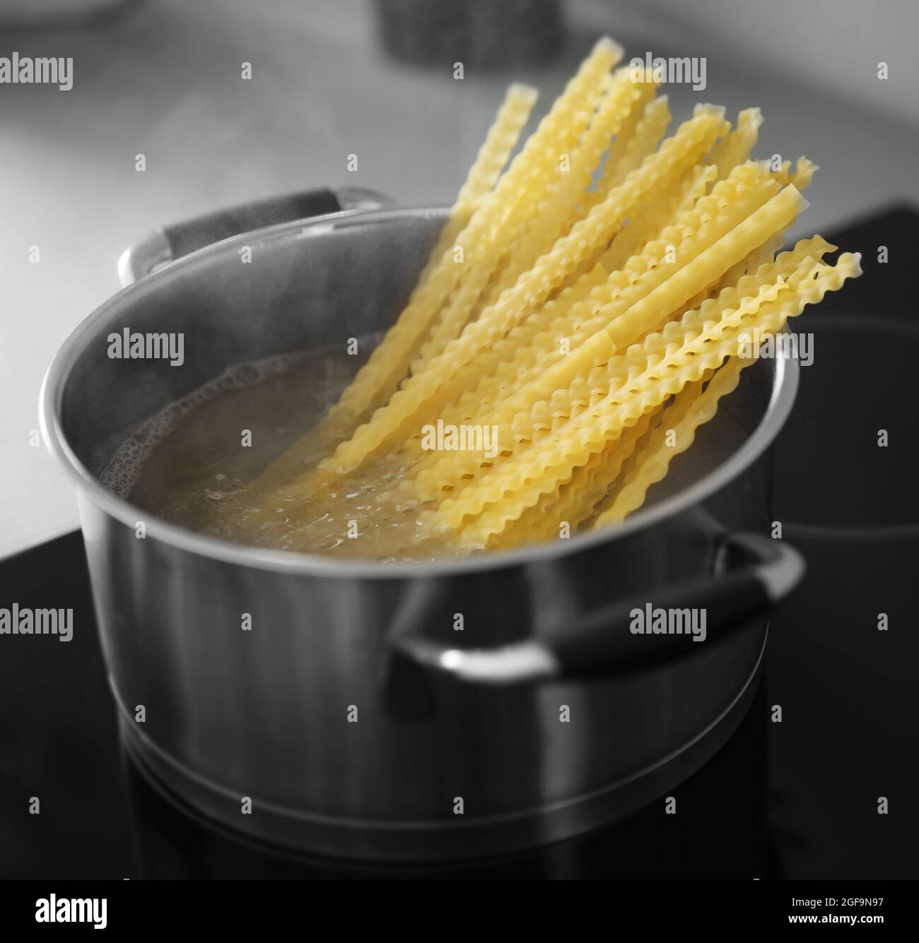 Boiling pasta in pan on electric stove in the kitchen Stock Photo - Alamy
