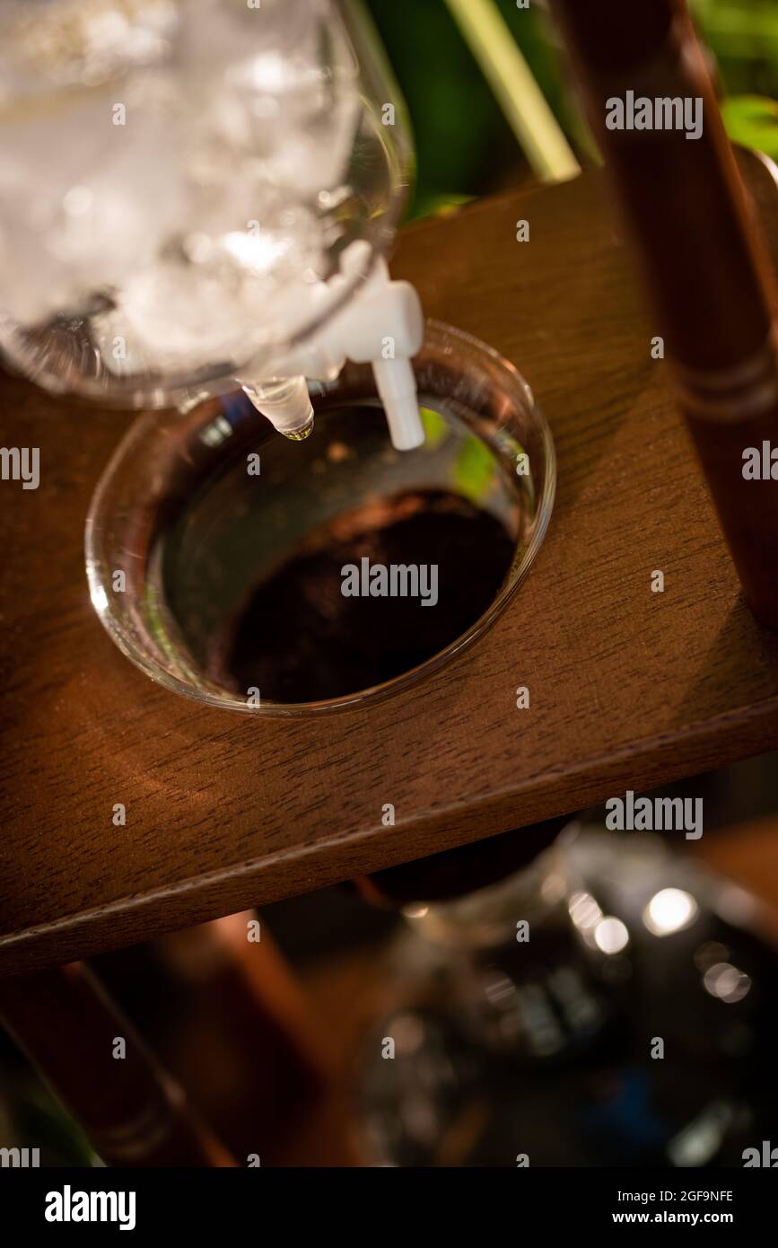 cold drip coffee tower with soft-focus and over light in the background ...