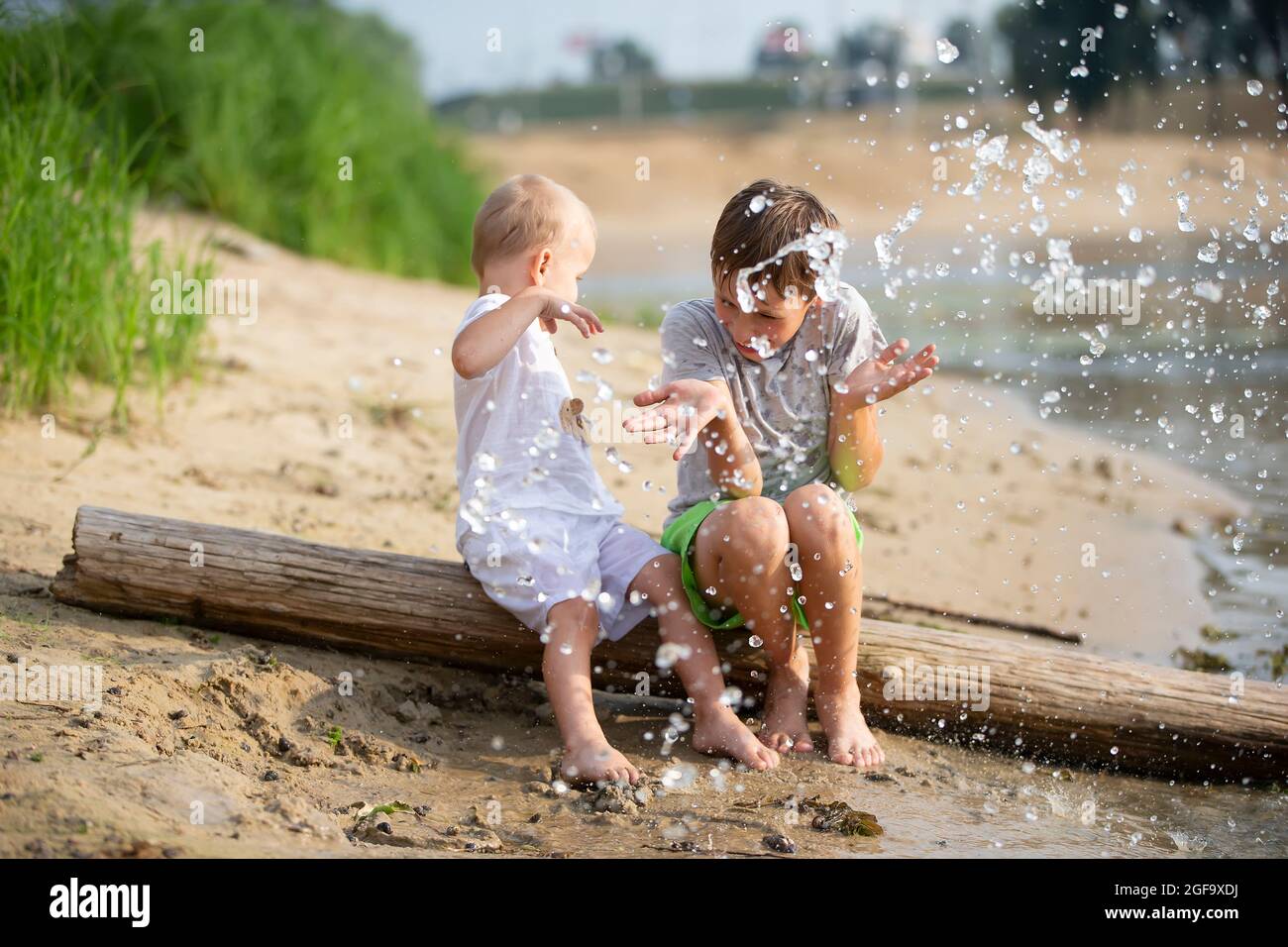 Water splashes are flying at children playing on the river bank Stock ...