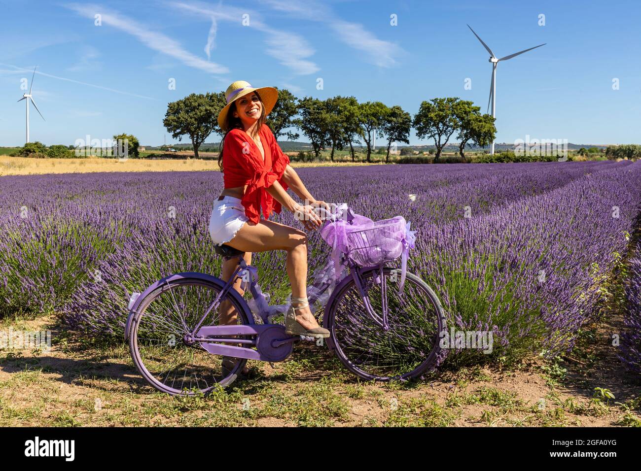 Cycling in Italy. A happy young woman is sitting on her bicycle in the ...