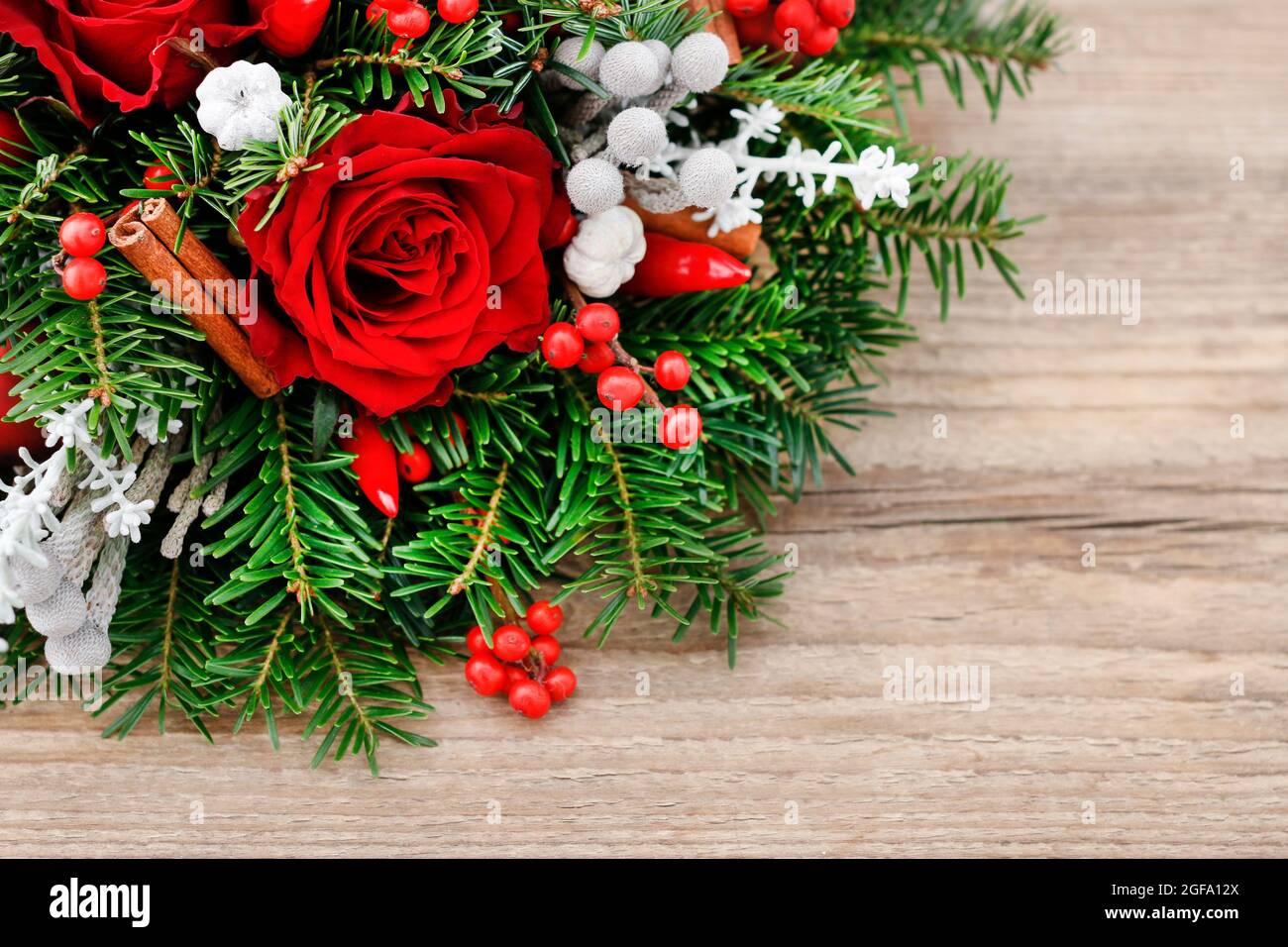 Christmas table centerpiece with fir, roses, balls and ilex twigs, copy ...