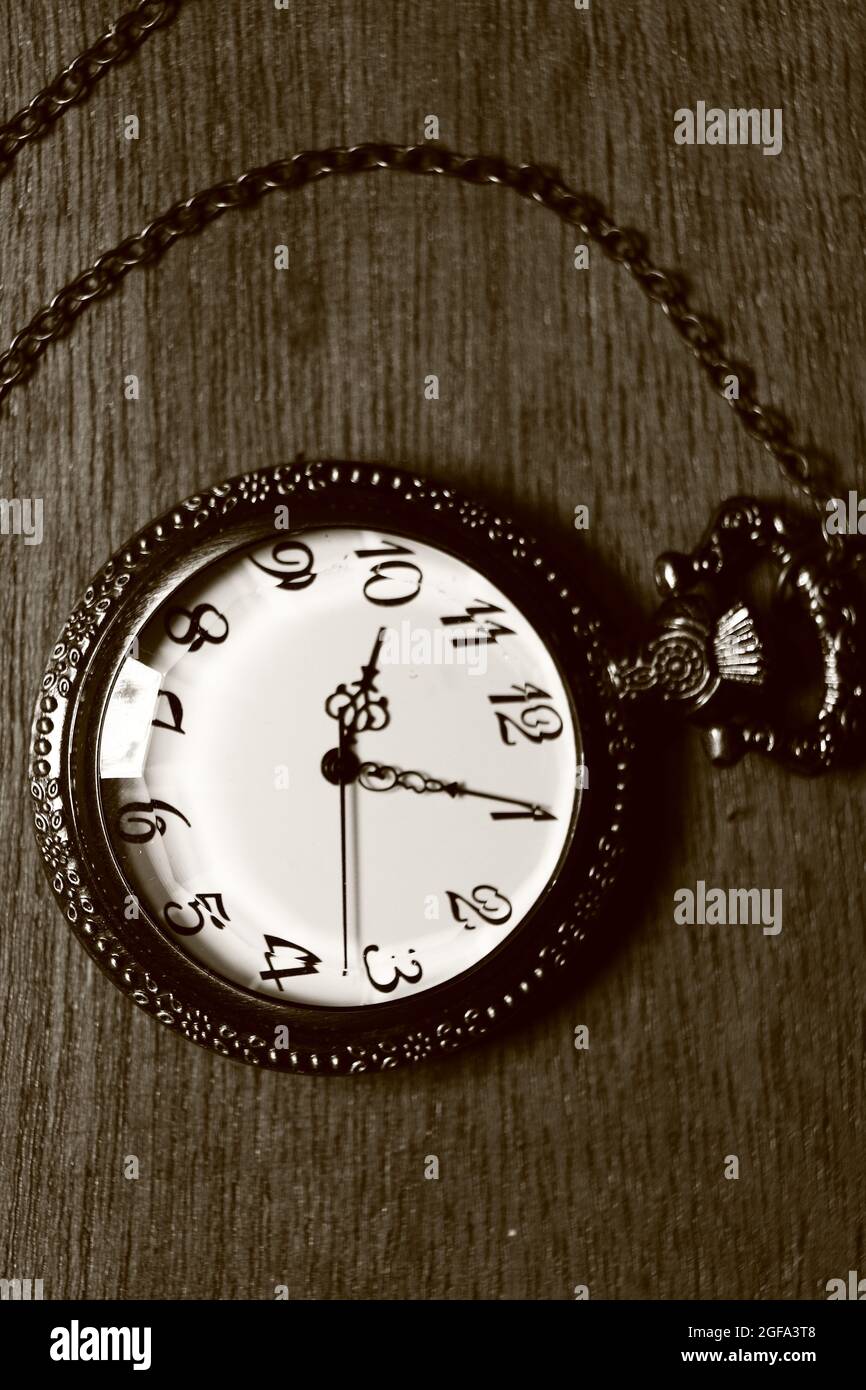 Old pocket watch with chain against wooden background Stock Photo - Alamy