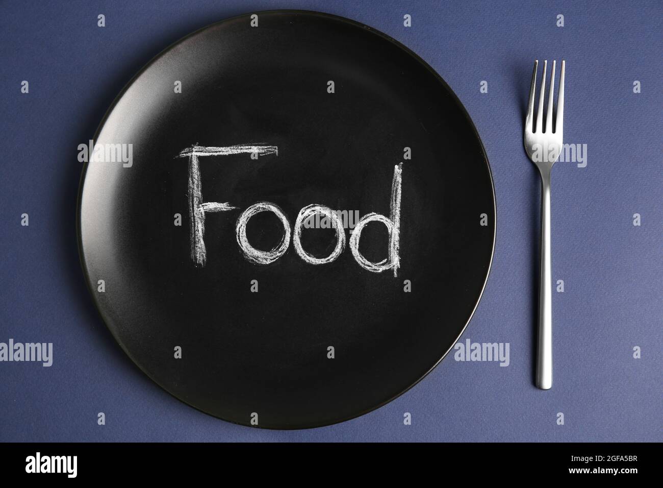 Plate with word FOOD on blue background Stock Photo - Alamy