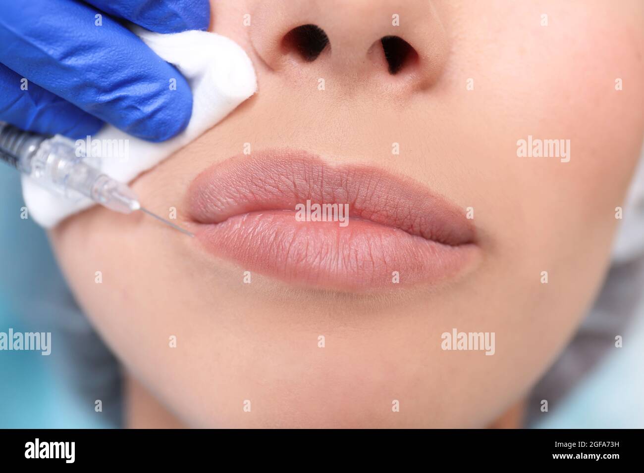 Young woman receiving plastic surgery injection on her face, closeup ...