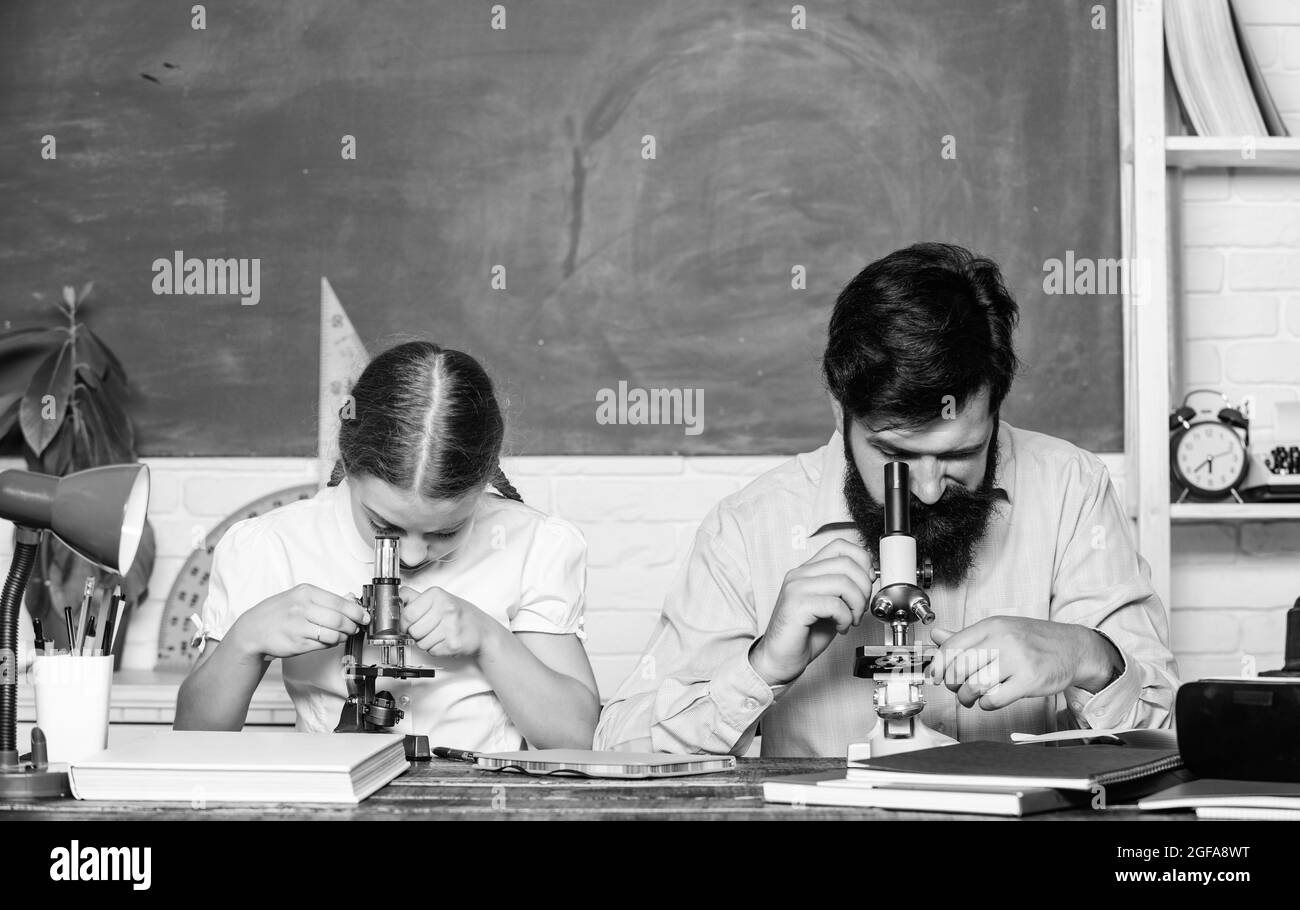 Study hard. Following example. Girl pupil study with bearded teacher ...