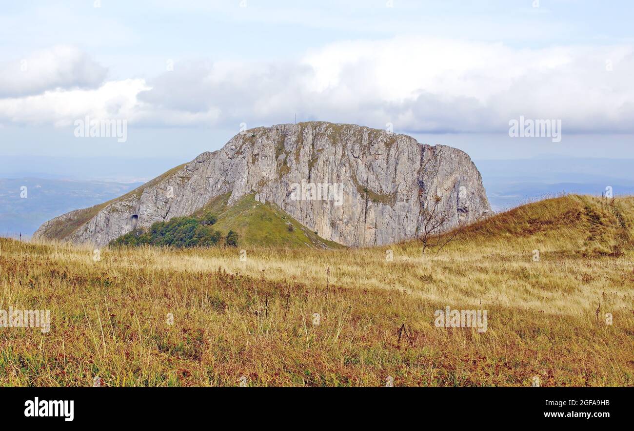 Shot of a gray cliff standing in the middle of a broad field Stock ...