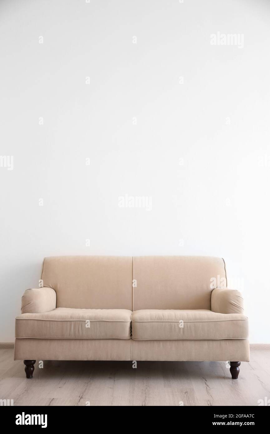 Cozy couch on wall background Stock Photo - Alamy