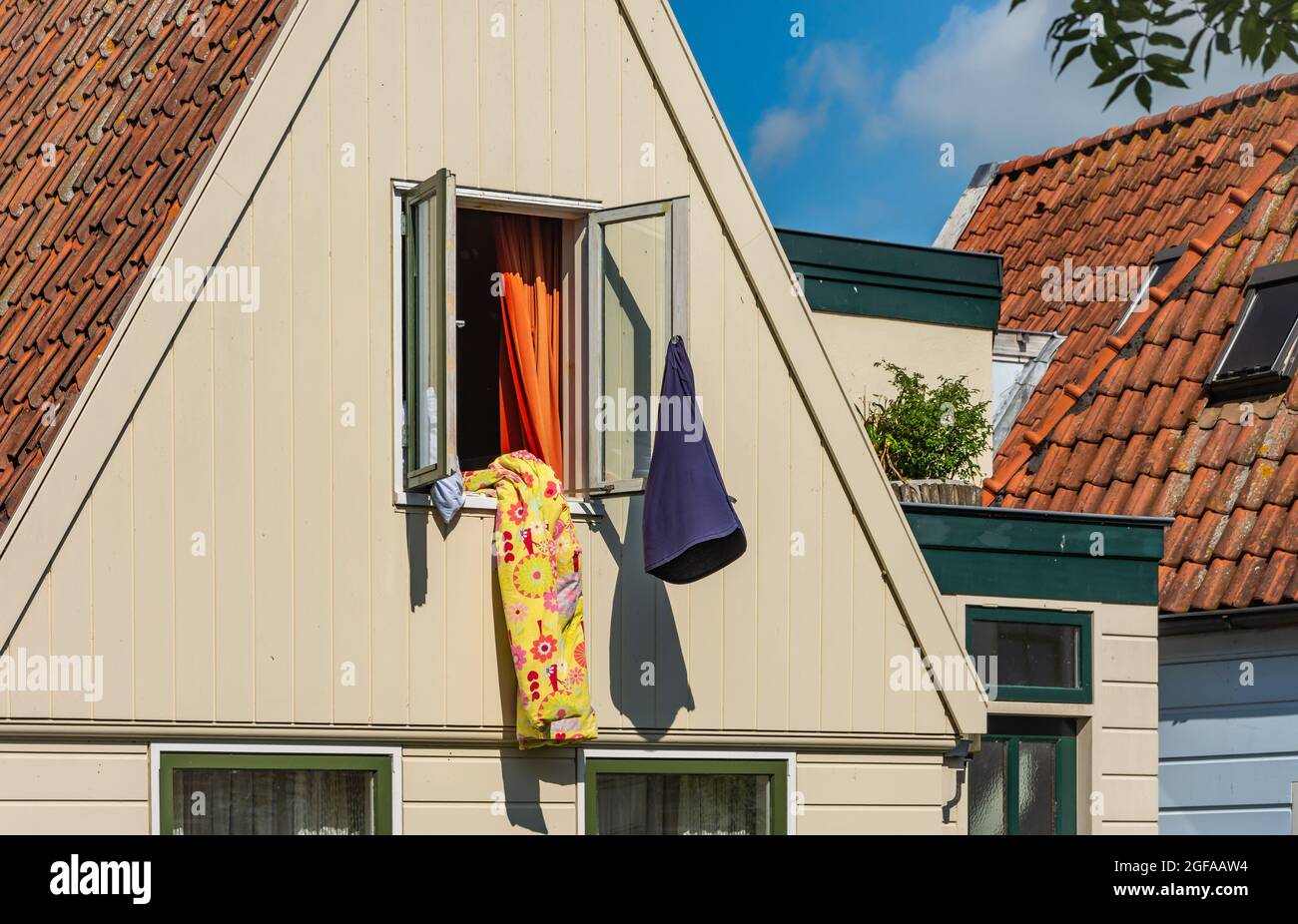 Colorful blanket hanging out of the window of the dutch house, bed ...