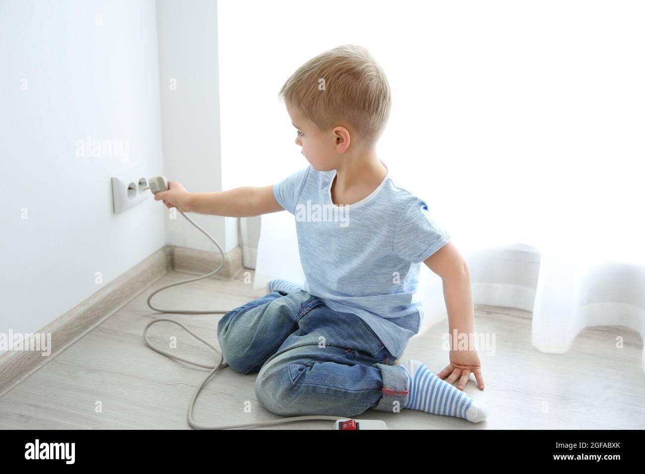 Little baby playing with plug Stock Photo - Alamy