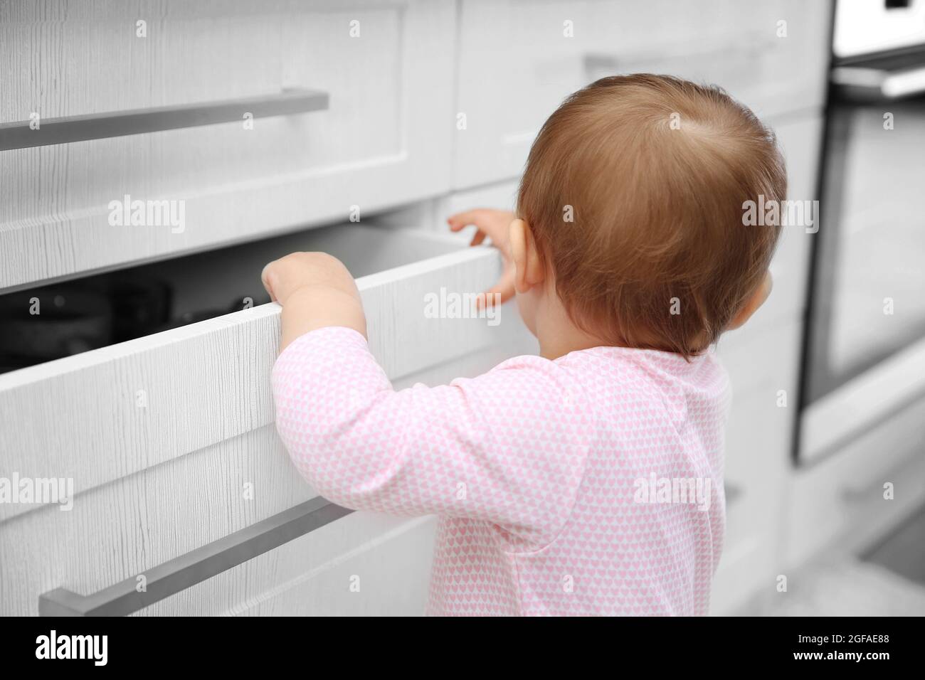 Little child playing with drawer Stock Photo - Alamy