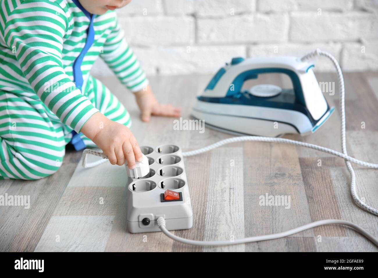 Little child playing with iron and electric power bar at home Stock ...