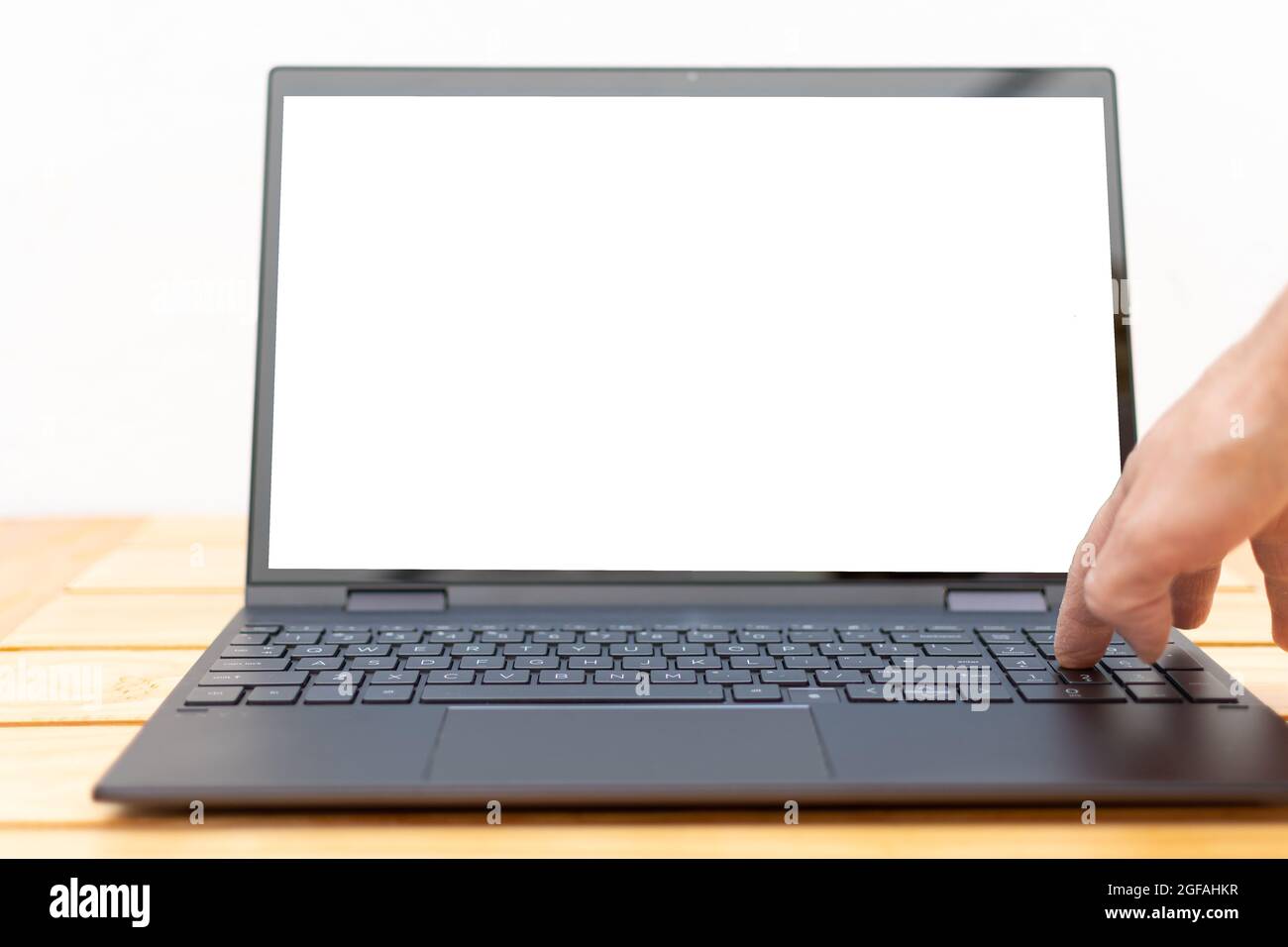 Man operating the numeric keypad of a laptop with the blank screen ...