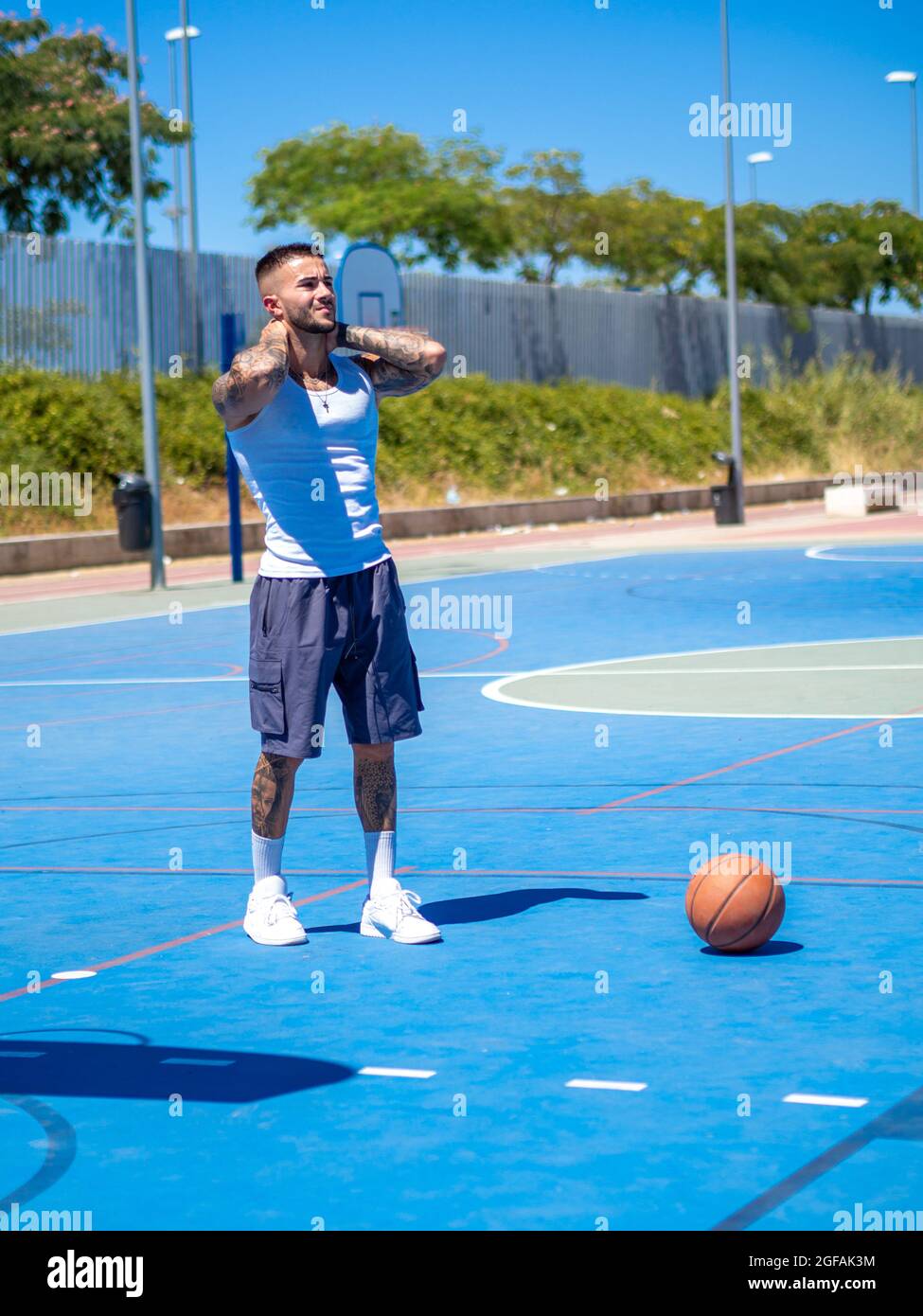 Athletic handsome Spanish basketball player training on a basketball ...