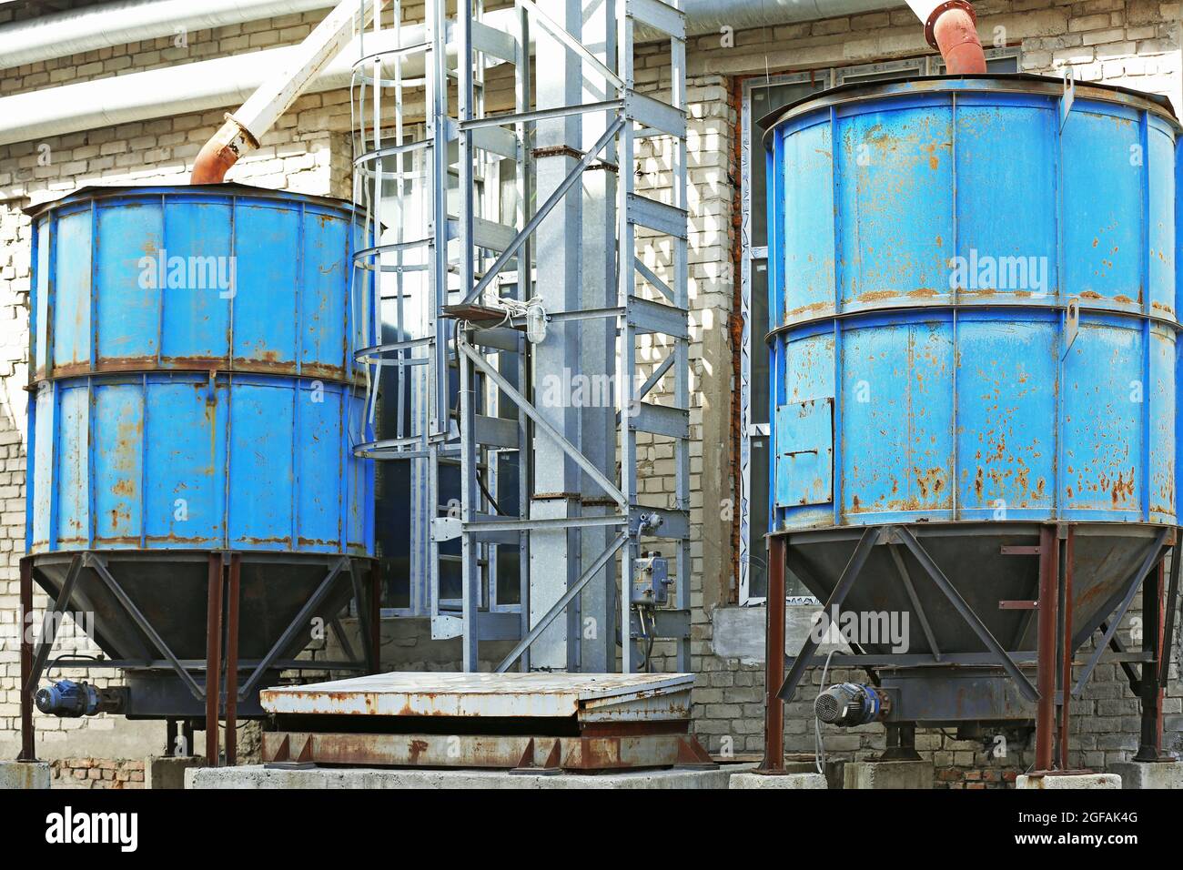 Old big blue tanks on the factory Stock Photo - Alamy