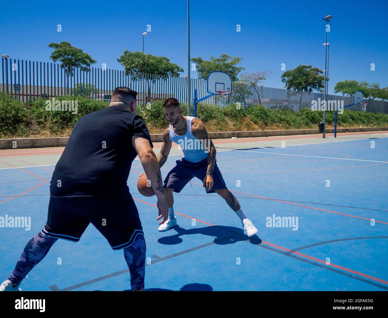 Athletic handsome Spanish basketball players training on a basketball ...