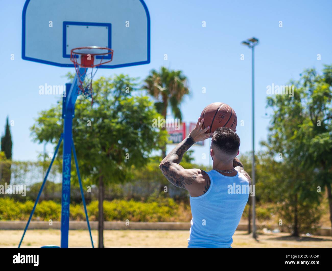 Athletic handsome Spanish basketball player training on a basketball ...