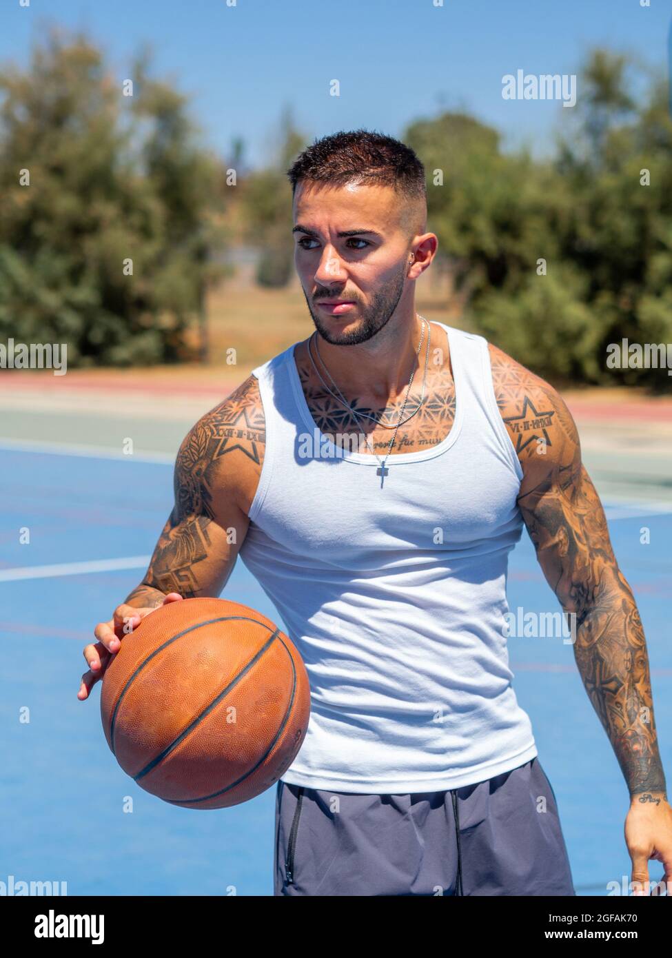 Athletic handsome Spanish basketball player training on a basketball ...