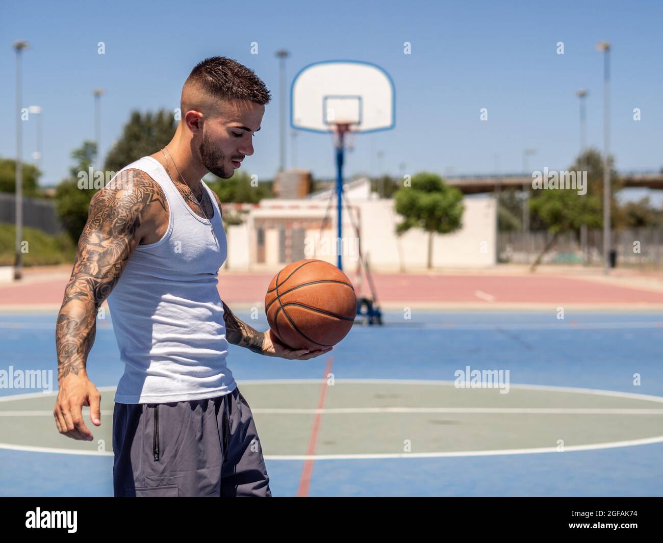 Athletic handsome Spanish basketball player training on a basketball ...