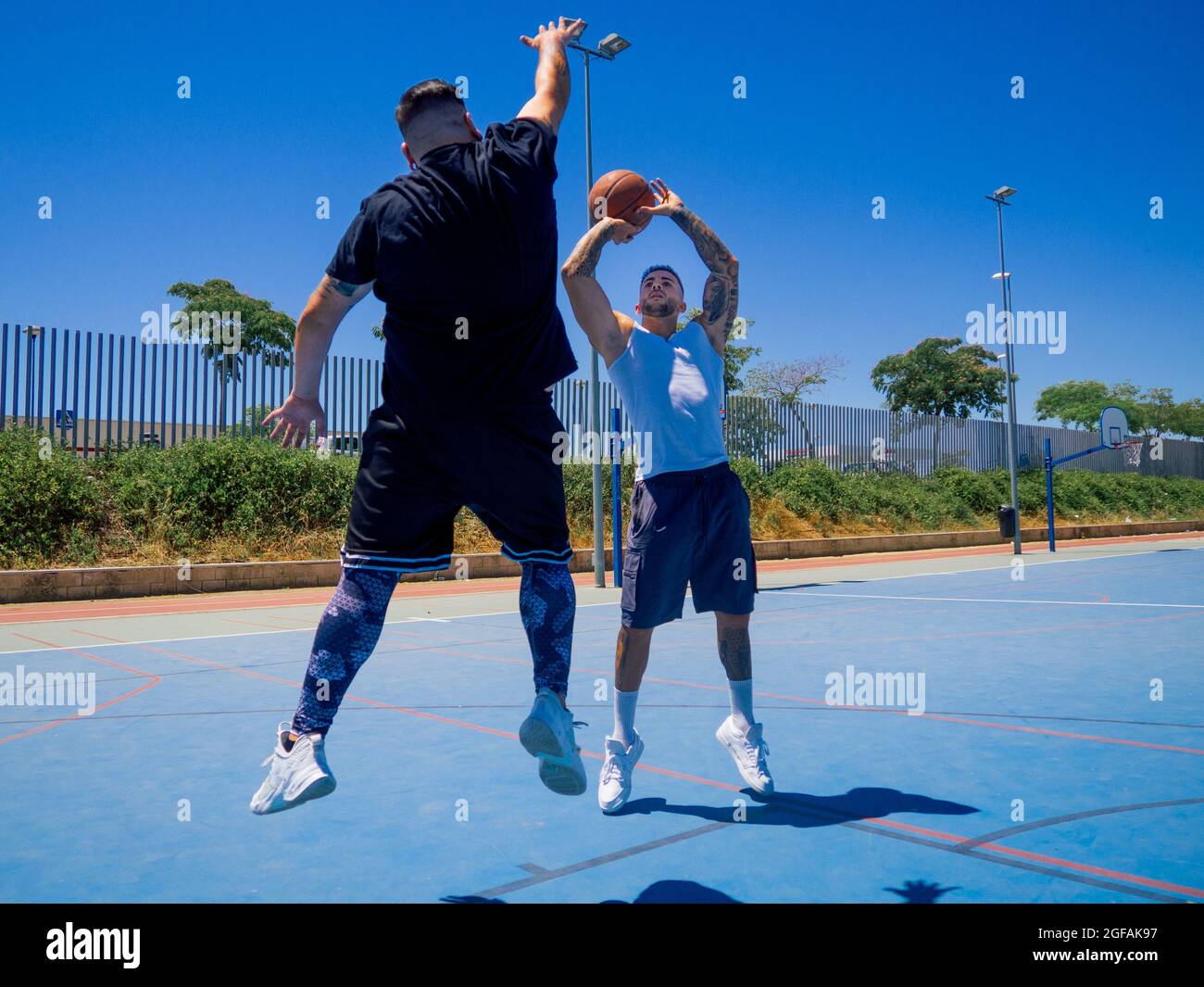 Athletic handsome Spanish basketball players training on a basketball ...