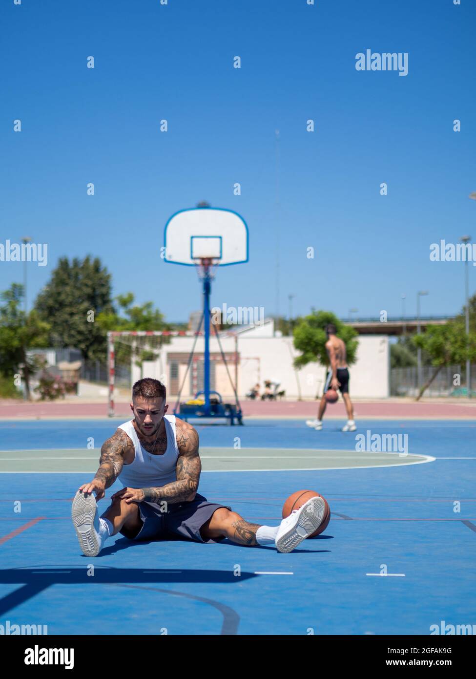 Athletic handsome Spanish basketball player training on a basketball ...