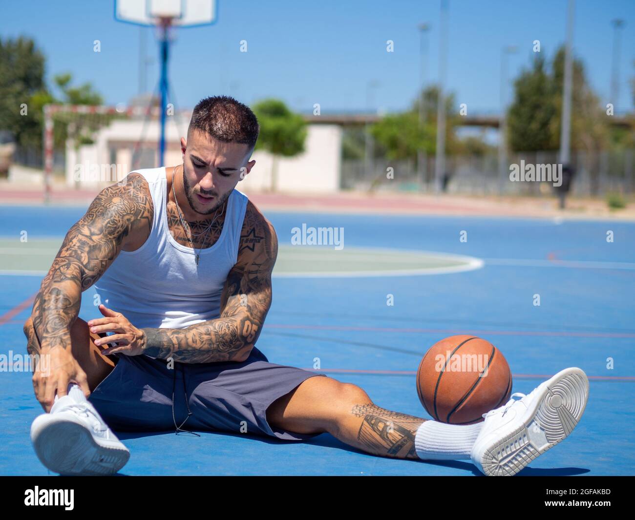 Athletic handsome Spanish basketball player training on a basketball ...