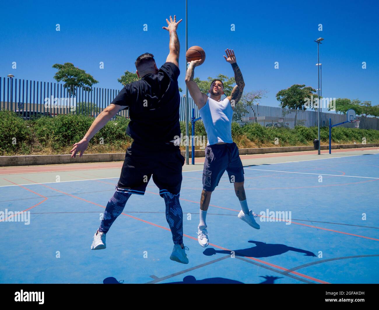 Athletic handsome Spanish basketball players training on a basketball ...