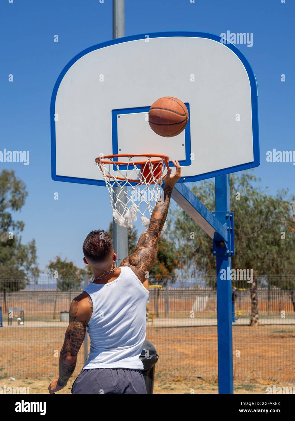 Athletic handsome Spanish basketball player training on a basketball ...