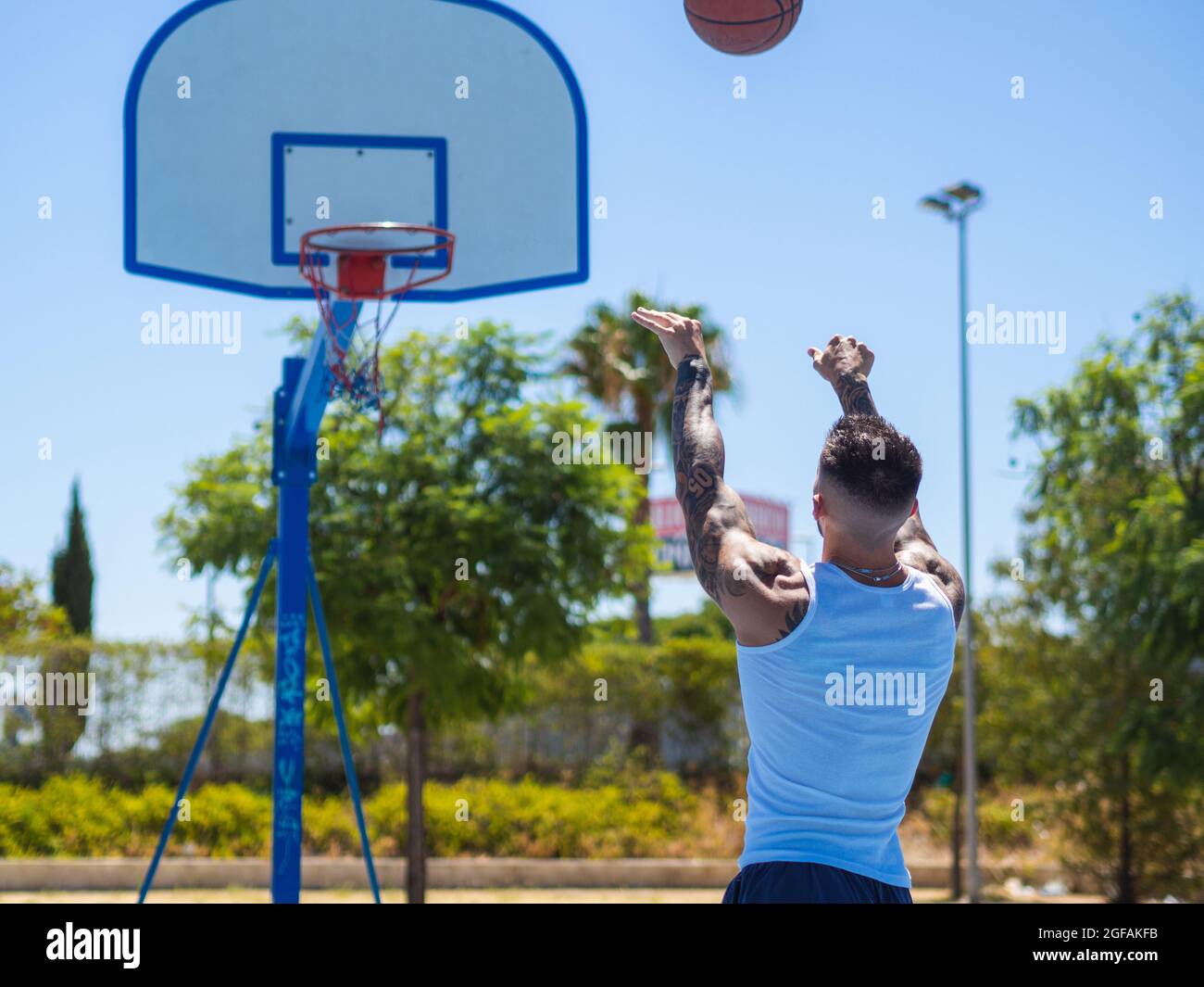 Athletic handsome Spanish basketball player training on a basketball ...