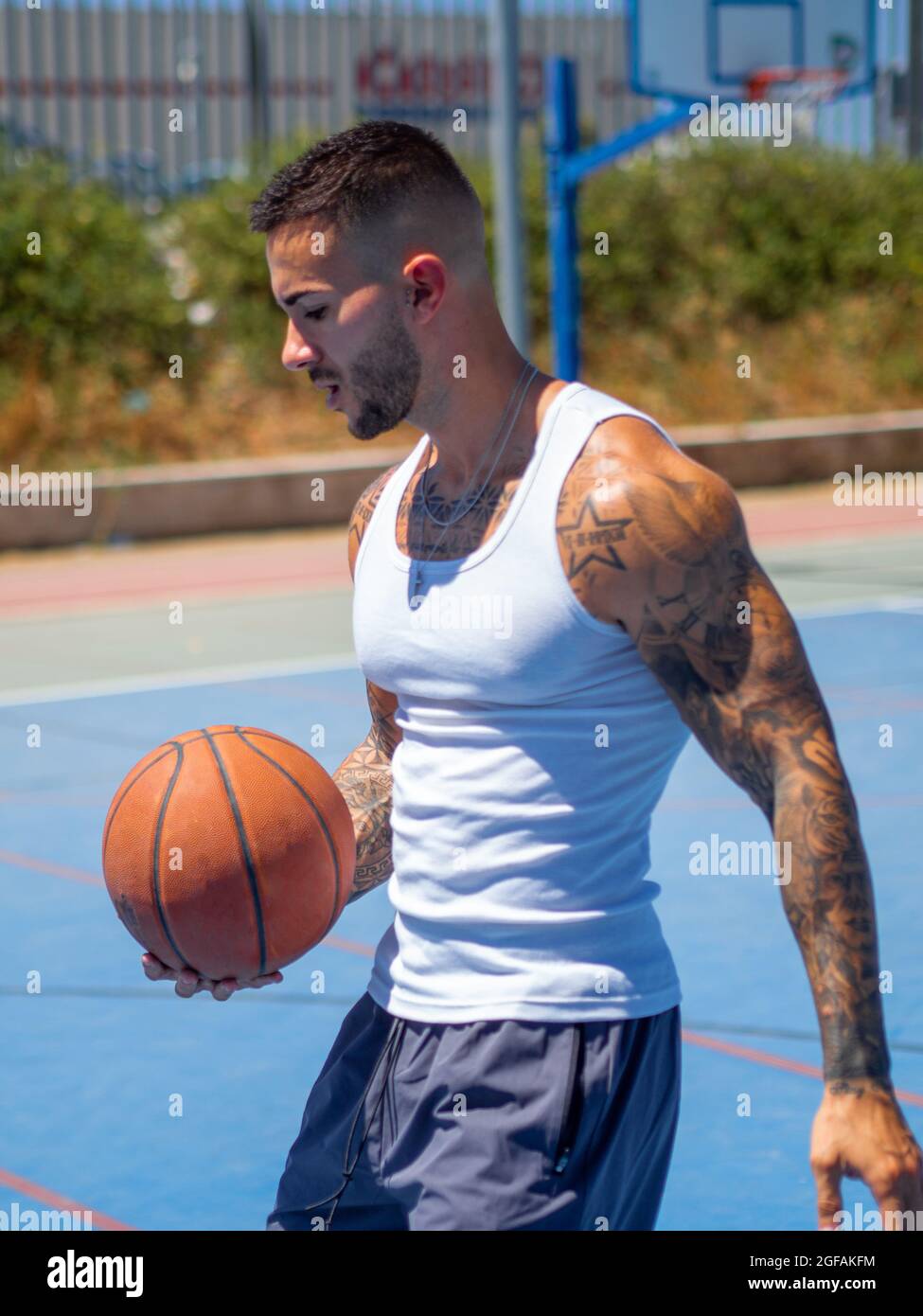 Athletic handsome Spanish basketball player training on a basketball ...