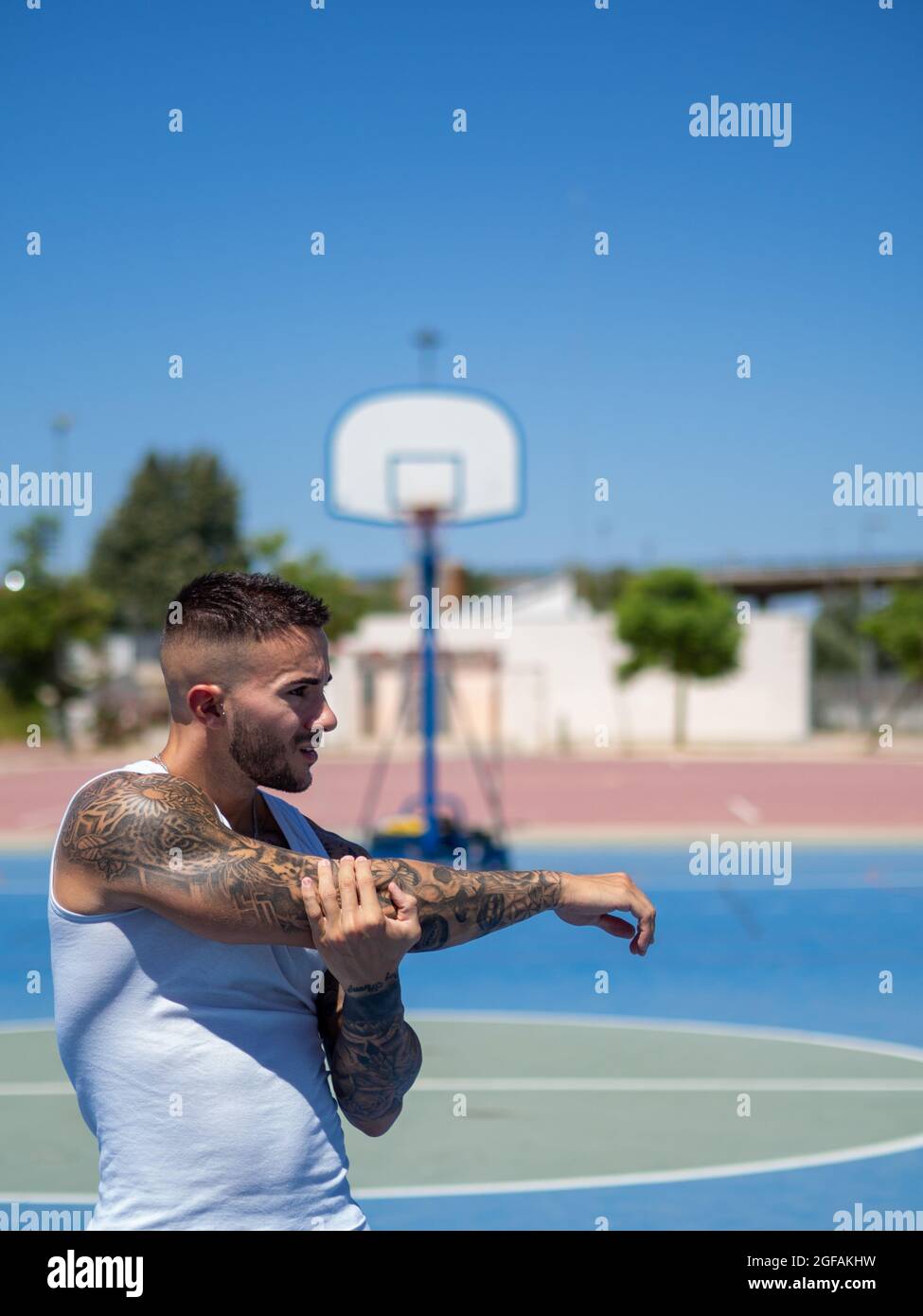 Athletic handsome Spanish basketball player training on a basketball ...