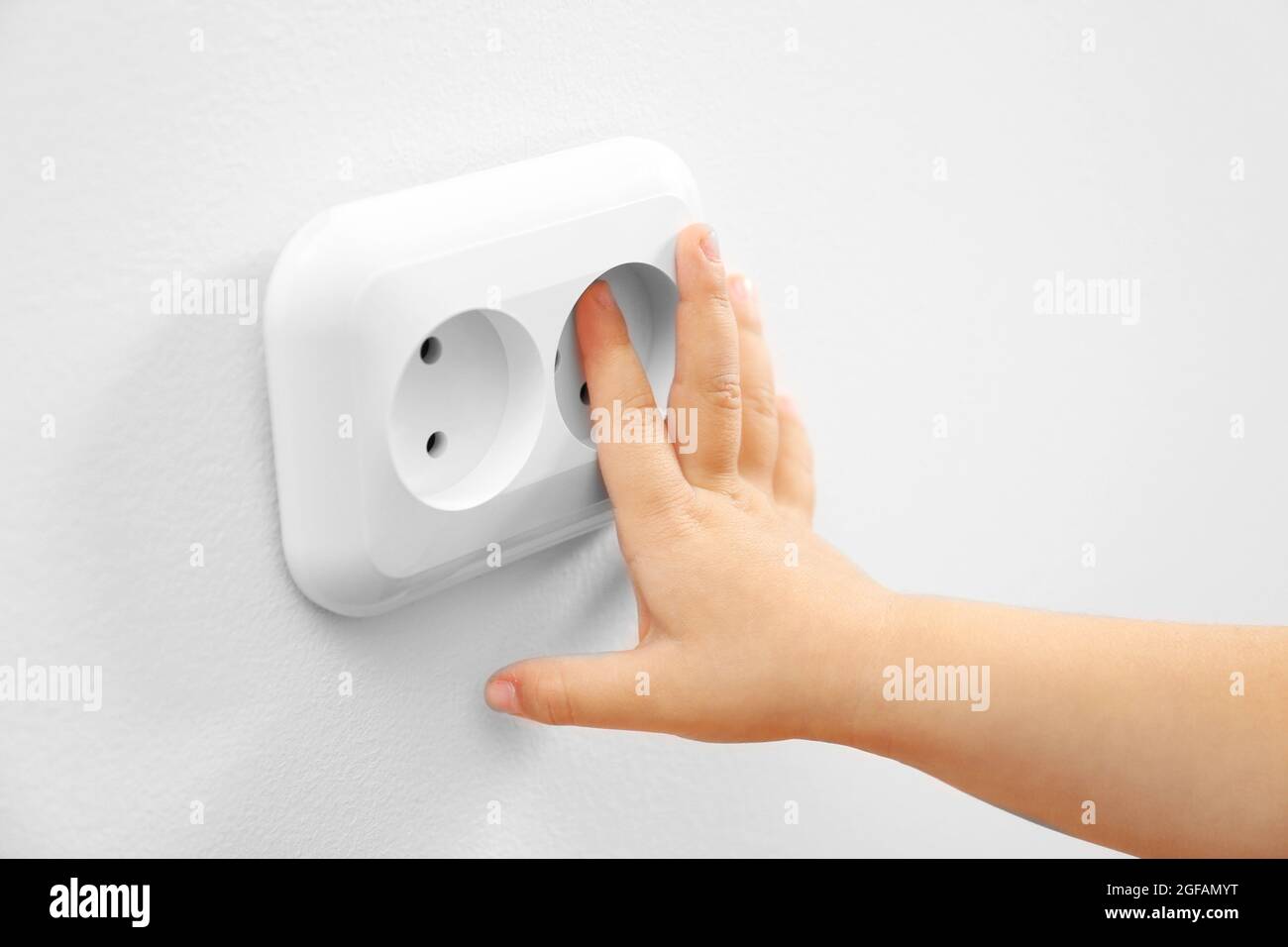 Little child putting finger in power socket, closeup Stock Photo - Alamy