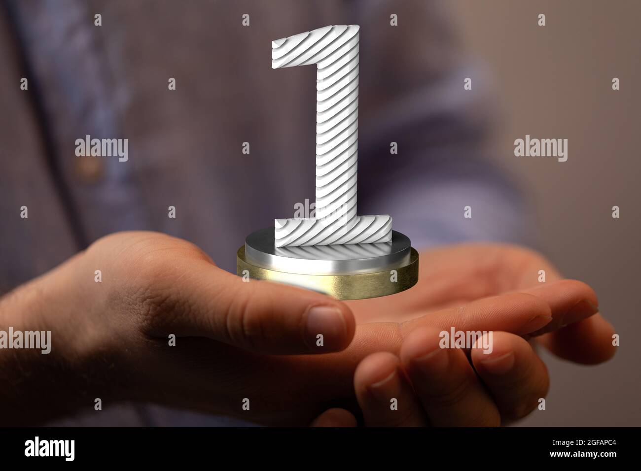 Male's hand holding an illustration of a first place prize gold medal ...