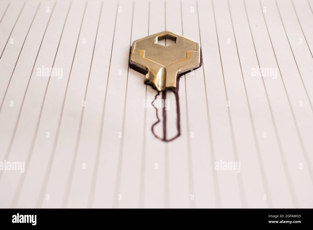 Metal broken key on a dasign of a key on a white background with ...