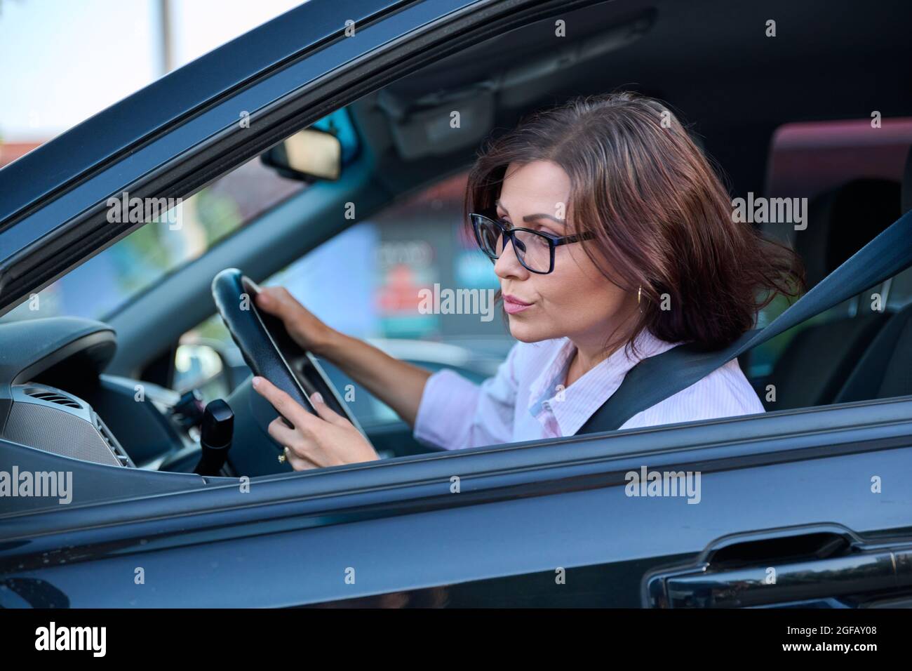 Middle-aged beautiful woman driver driving a car Stock Photo - Alamy