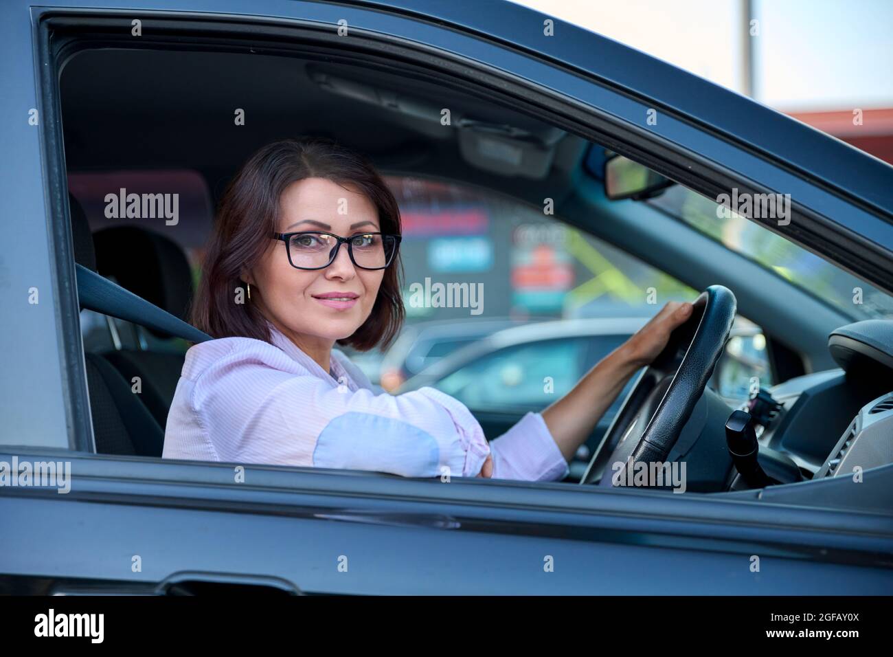 Middle-aged beautiful woman driver driving a car Stock Photo - Alamy