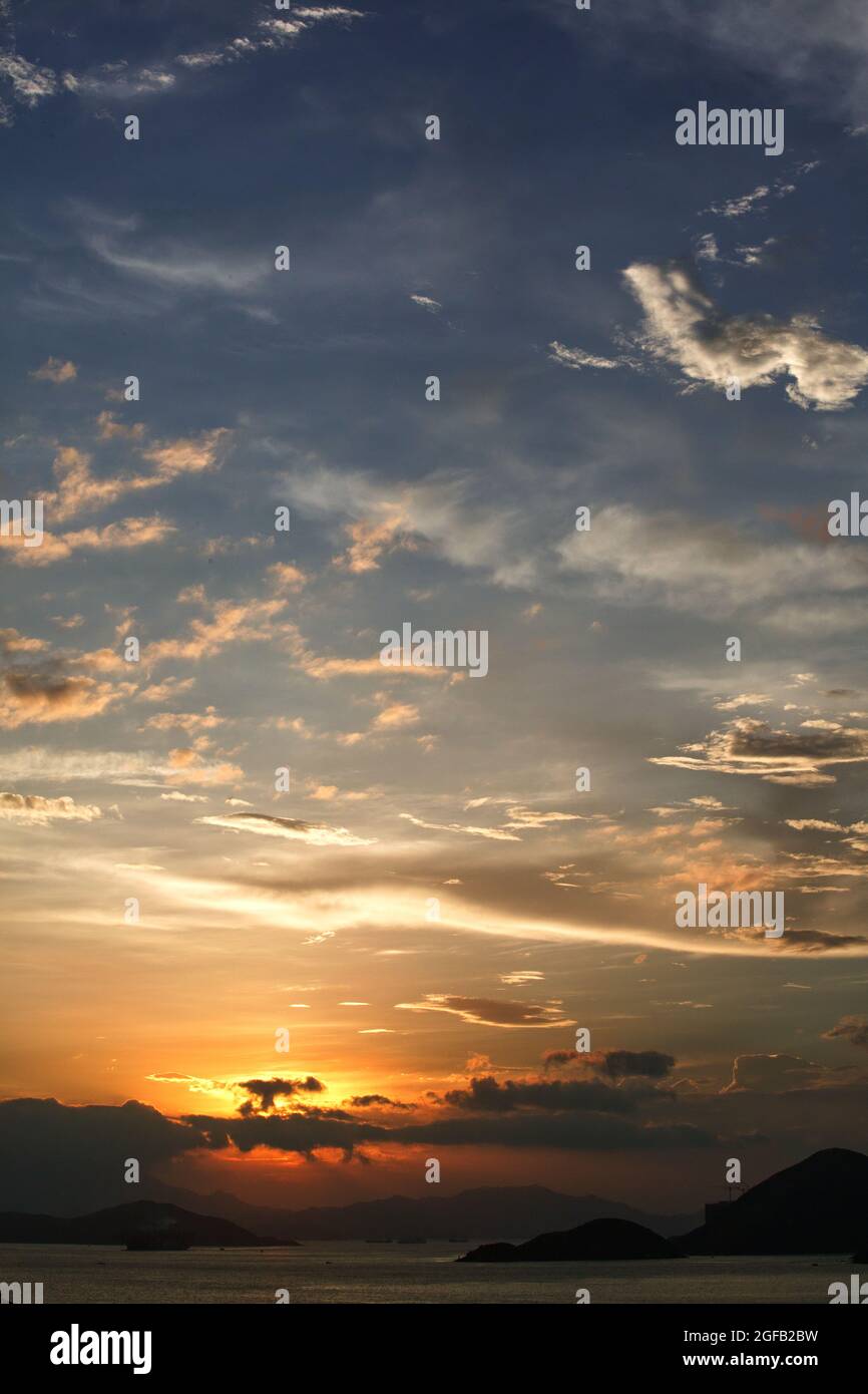Beautiful view of the sea gleaming under the sunset in the cloudy blue ...