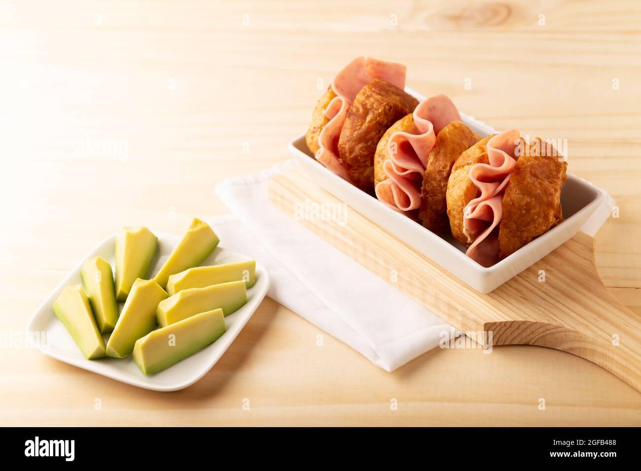 Mini ham sandwich made with "Hojaldra" accompanied by sliced avocado ...