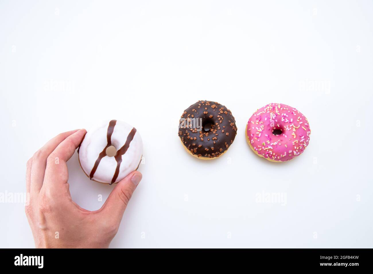 Top view of three donuts on an isolated white background with a hand ...