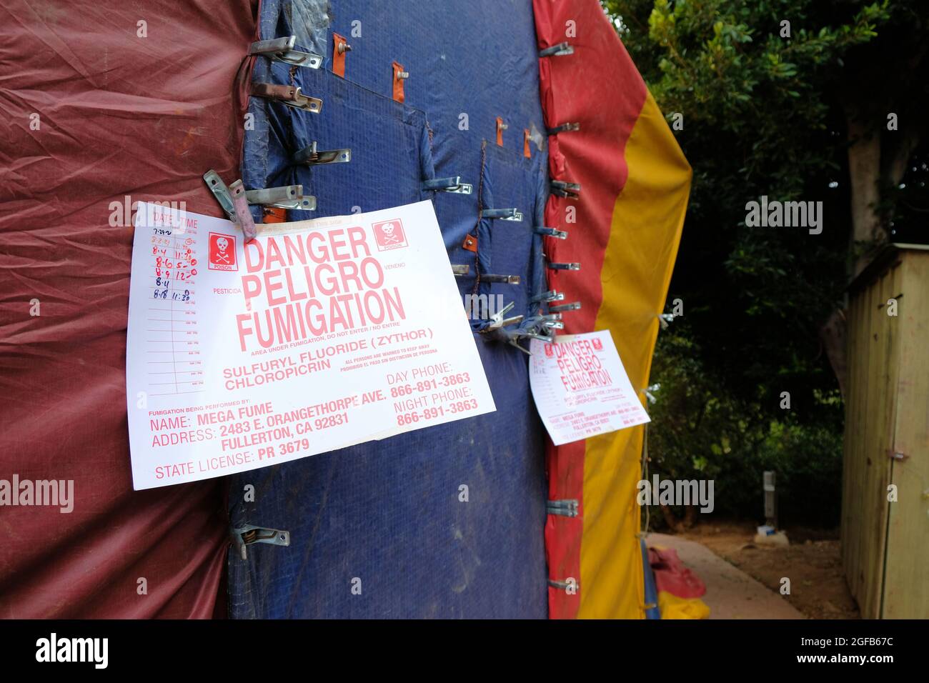 Warning sign posted on a tent covering a home alerting of the dangers ...
