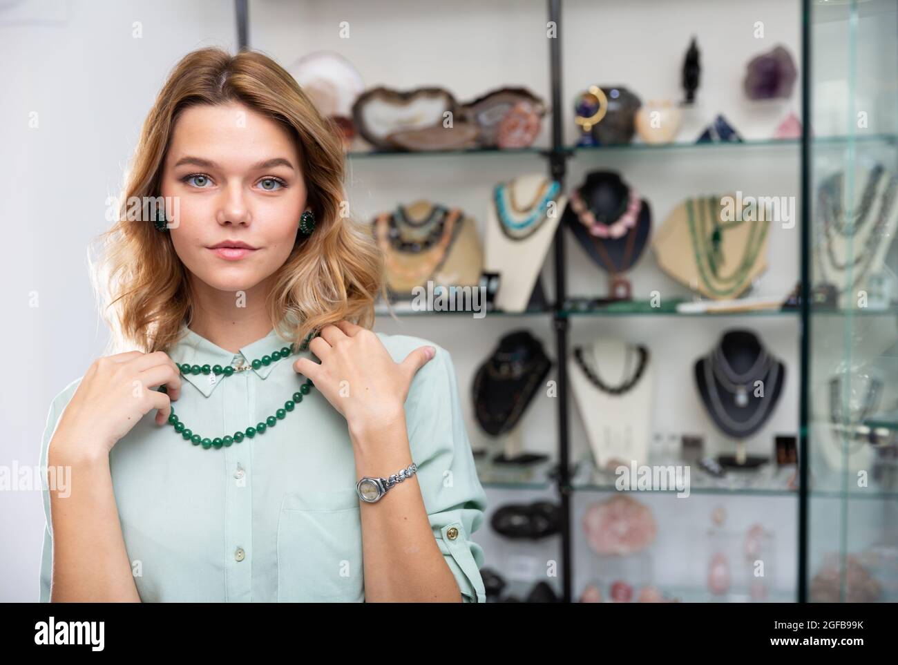 Female client trying on green nephrite beads Stock Photo - Alamy
