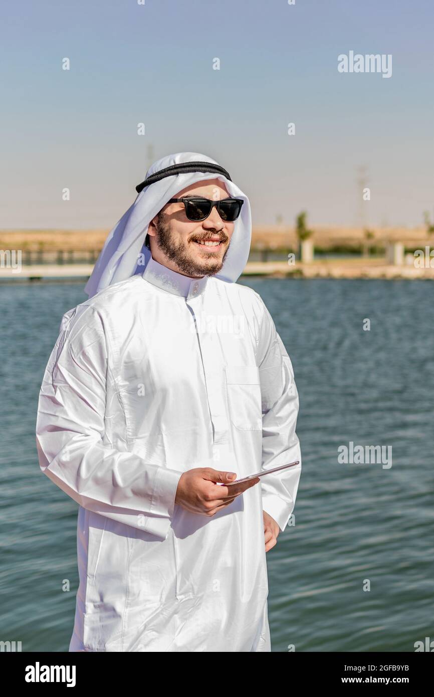 Vertical shot of a happy Muslim man in traditional clothing, smiling ...