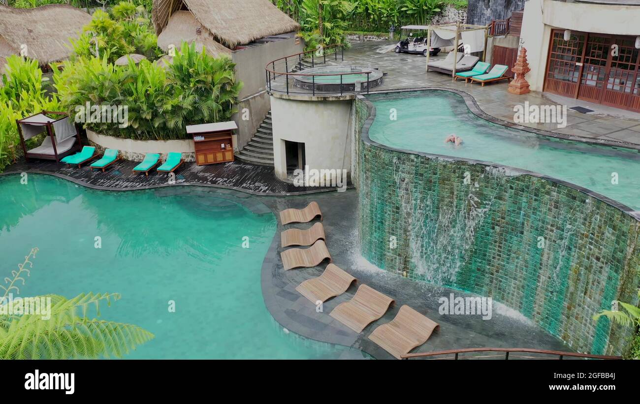 Infinity Pool with water pouring over white tiled edge Stock Photo - Alamy
