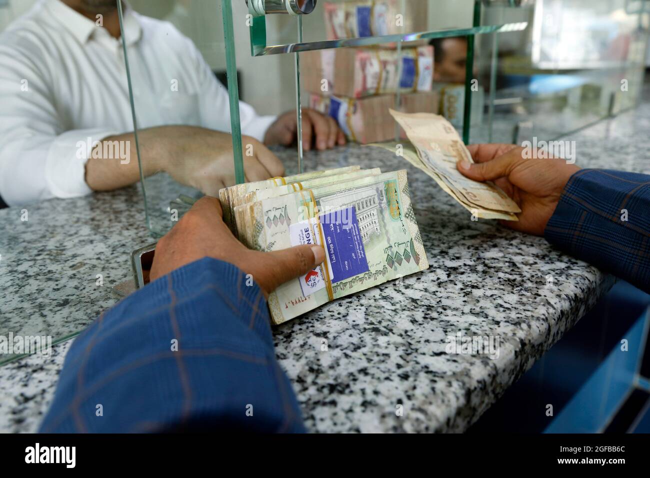 Sanaa. 24th Aug, 2021. A Yemeni man exchanges for cash inside a foreign ...