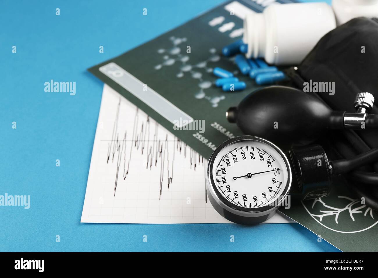 Medical manometer, pills and medical record on blue background Stock ...