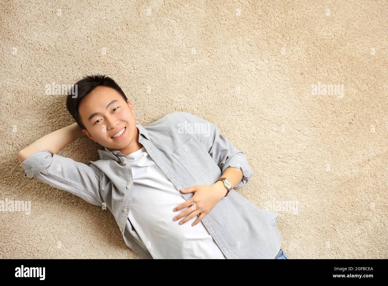 Handsome man lying on floor Stock Photo - Alamy